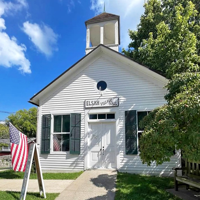 The pristine white Village Hall stands as Elsah's civic heart, complete with charming cupola and American flag &ndash; small-town governance at its most picturesque.