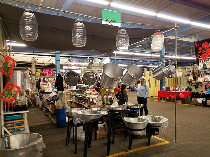 Kitchen dreams materialize under hanging pots and pans, where professional-grade cookware dangles like metallic wind chimes waiting for their forever homes.