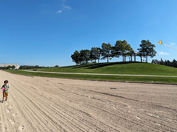 Sandy shores stretch toward a hilltop pavilion, where beach days unfold beneath endless blue skies. Sunscreen mandatory, worries optional.