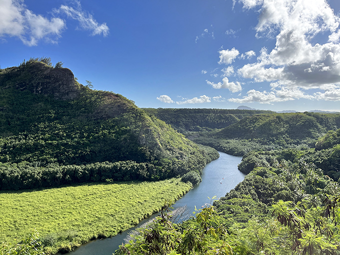 The Wailua River carves its ancient path through Kauai's lush landscape, a serpentine blue ribbon amid endless green.