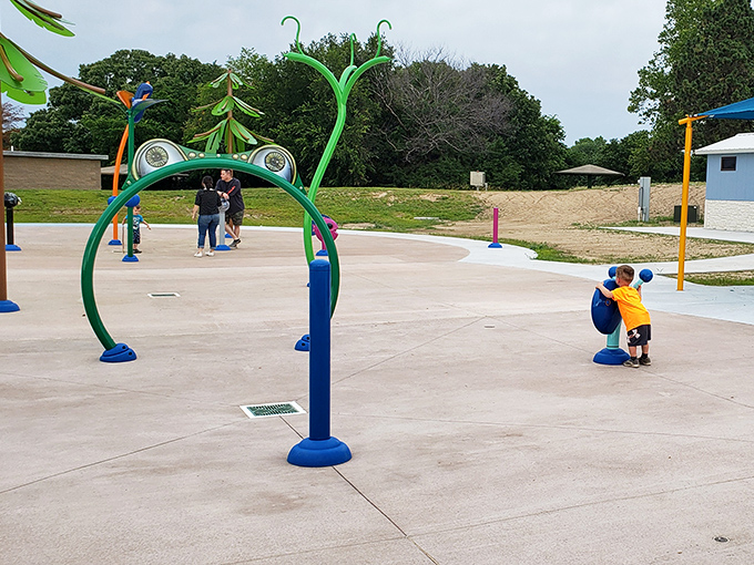 Who says water parks need admission tickets? This whimsical splash pad turns summer heat into childhood giggles with colorful sprayers that seem to dance.