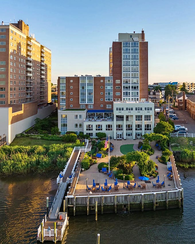 Riverside relaxation at its finest&mdash;blue umbrellas, manicured gardens, and waterfront views create an urban oasis where stress simply floats away.