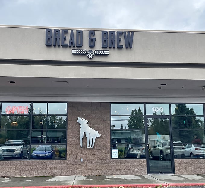 Bread & Brew's sleek storefront with that howling wolf logo &ndash; where sandwich artistry meets Alaska's wild spirit.