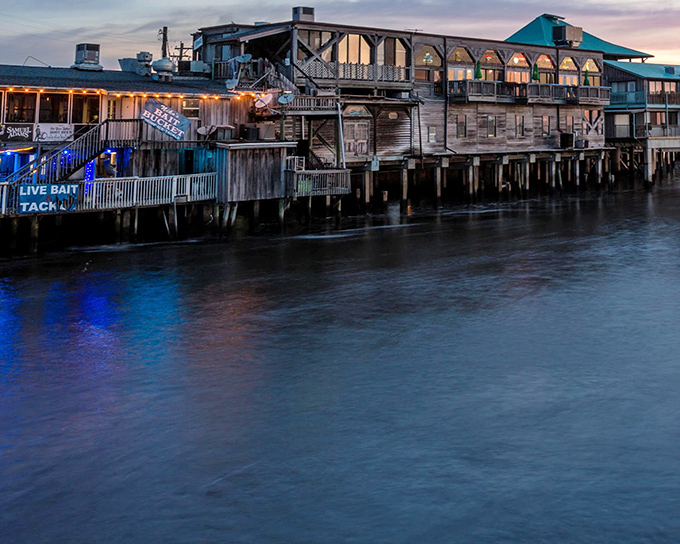 Cedar Key's weathered wooden buildings stand on stilts at sunset, creating a fishing village scene straight from a postcard.