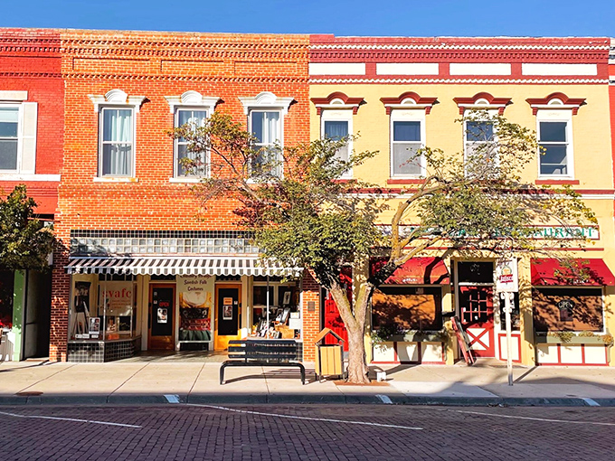 Lindsborg's vibrant storefronts pop with color against the blue sky, inviting window-shoppers to discover treasures behind each door.