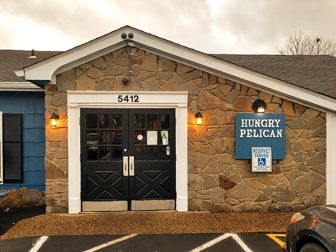 The Hungry Pelican's cozy stone exterior with its distinctive blue sign welcomes seafood lovers to this hidden gem in Fern Creek.