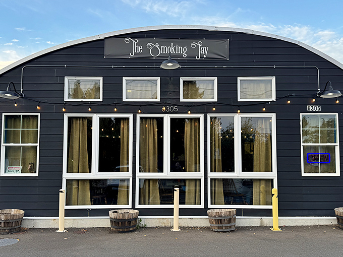 The Smoking Jay looks like a cozy cabin that accidentally became barbecue heaven. Those string lights promise good times ahead!