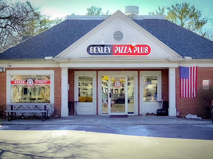 Morning light bathes Bexley Pizza Plus in a golden glow, promising pizza perfection behind those welcoming doors.