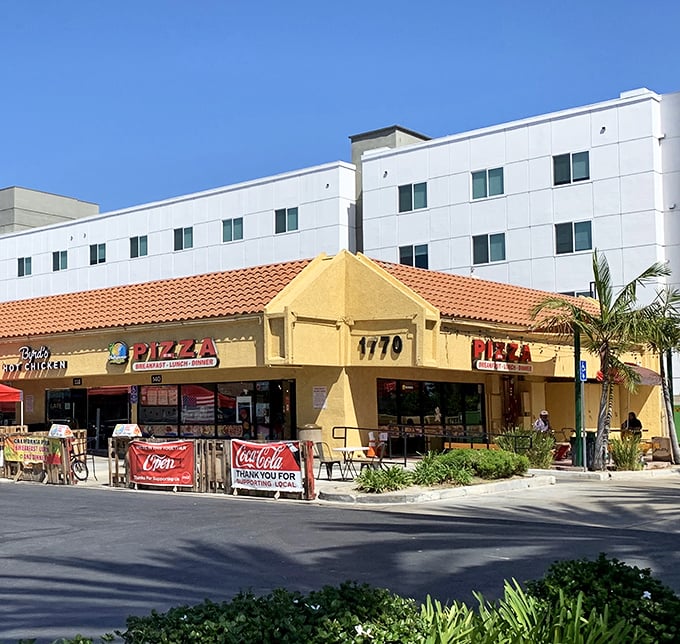 This sunny yellow building houses California Pizza Place, a slice of Americana where palm trees and pizza create the perfect California dream.