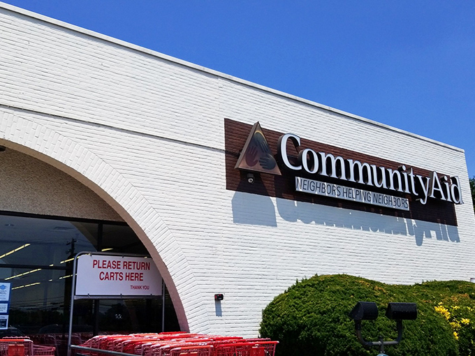 The bright white exterior of Community Aid shines under blue skies, promising a clean, organized thrifting experience unlike typical secondhand shops.