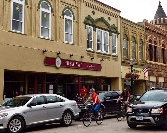 Cyclists and shoppers share Decorah's vibrant main street, where brick buildings house treasures waiting to be discovered.