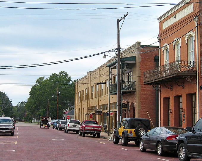 Red brick streets wind past century-old storefronts where time seems to have paused mid-stride.