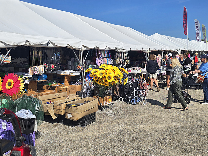 Bright sunflowers and sunny skies welcome shoppers to a bustling outdoor market day. Find your next favorite treasure!