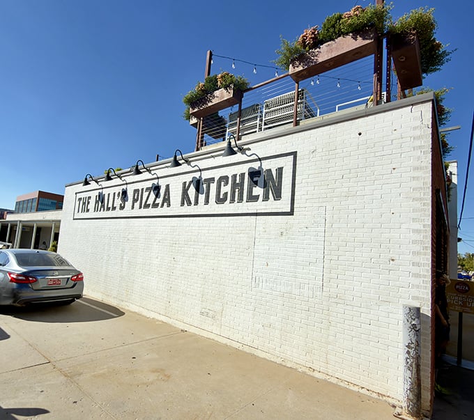 Sleek white brick and hanging plants create an urban oasis. The Hall's Pizza Kitchen proves great pizza can come in stylish packages.