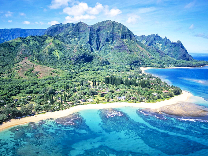 Mountains doing their best Jurassic Park impression while Wainiha's beaches sparkle below like scattered diamonds on velvet.