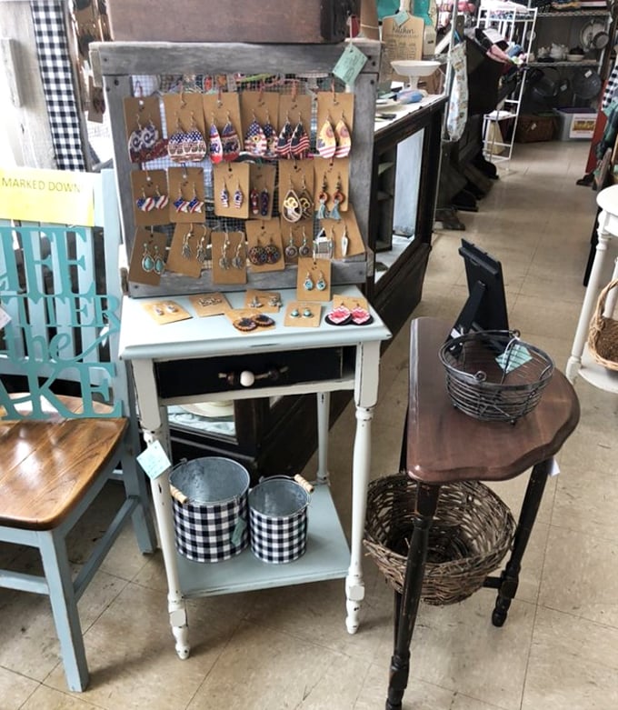 Handcrafted earrings displayed on a weathered frame&mdash;the perfect metaphor for this place where old materials find new purpose and beauty.