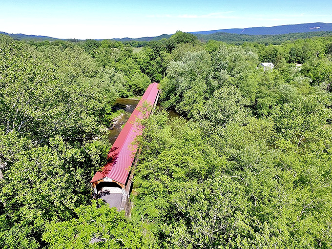 From above, it's a crimson ribbon threading through a sea of green. The bridge's distinctive red roof creates a perfect bullseye for daydreamers.