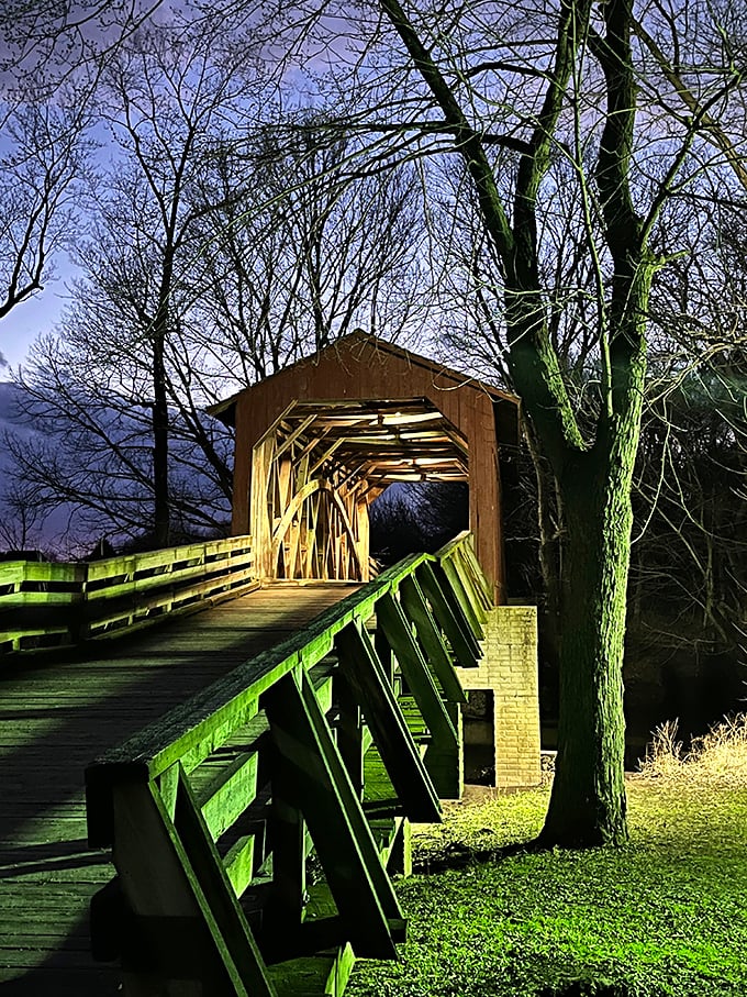 As twilight falls, the bridge transforms into something magical, as if Norman Rockwell and Edward Hopper collaborated on a painting.