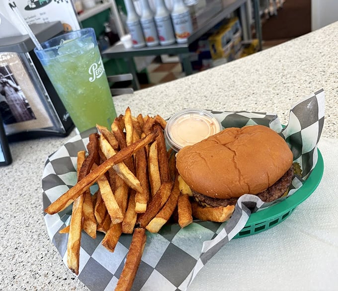 The holy trinity of diner perfection: a perfectly proportioned burger, hand-cut fries, and a lime green soda that whispers, "Take the afternoon off."
