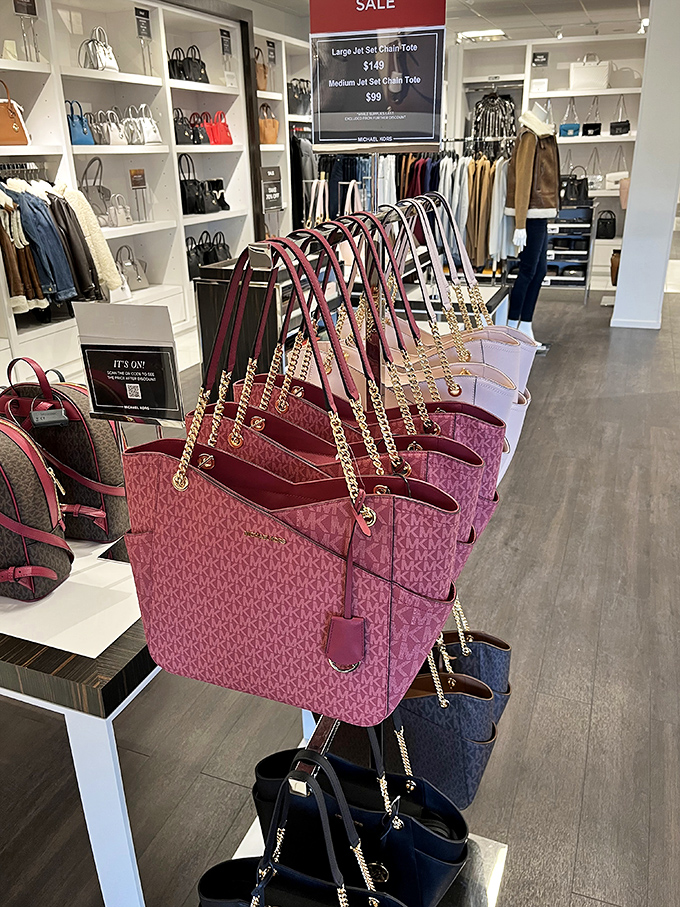 A lineup of Michael Kors bags standing at attention like fashionable soldiers, ready to march home with savvy shoppers seeking luxury for less.