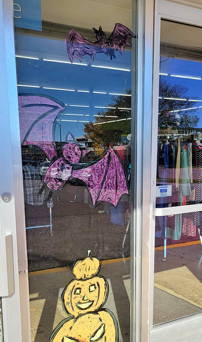 The seasonal window art transforms with the calendar&mdash;purple bats and cheerful pumpkins announce that Halloween treasures await inside.