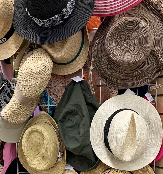 A symphony of sun hats dangles like possibilities&mdash;each one a different summer adventure waiting to happen.