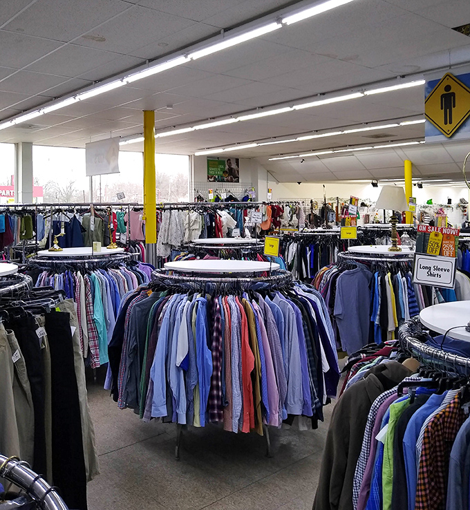 A sea of shirts organized by color creates a shopper's rainbow. Finding that perfect button-up feels like striking gold in this textile ocean.
