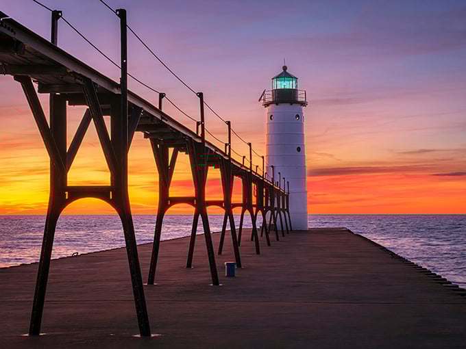 The North Pier Lighthouse creates the kind of sunset silhouette that belongs on postcards and in daydreams about perfect Michigan evenings.