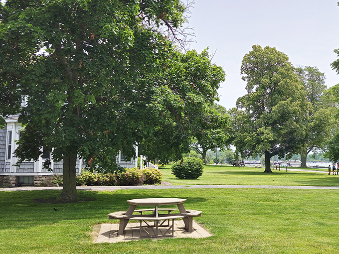 A picnic table waits patiently under shady trees at Memorial Park, nature's perfect dining room with Lake Erie views.
