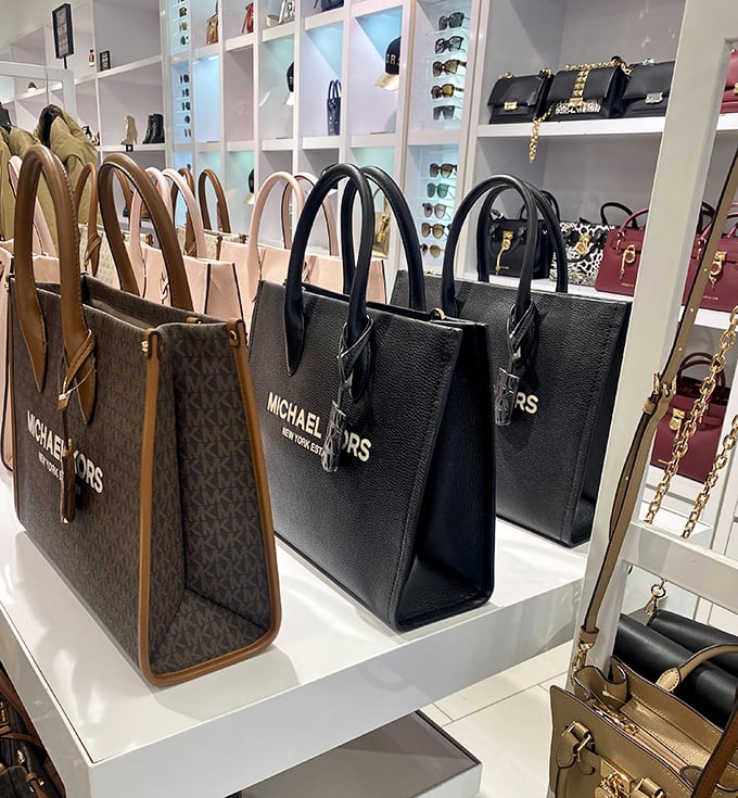 Michael Kors handbags displayed like art pieces, proving luxury doesn't always require a second mortgage payment.