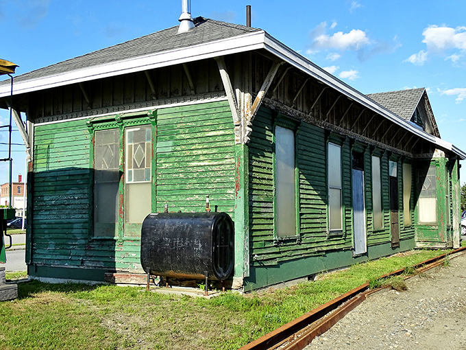 This weathered green depot stands as a time capsule of railroad history, when arrivals and departures marked the rhythm of small-town life.