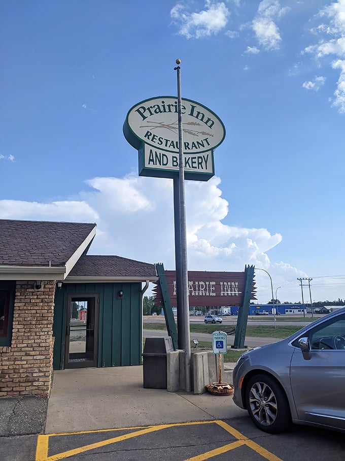 The Prairie Inn sign promises comfort food that hugs your soul like a Midwestern grandmother who knows her way around a kitchen.