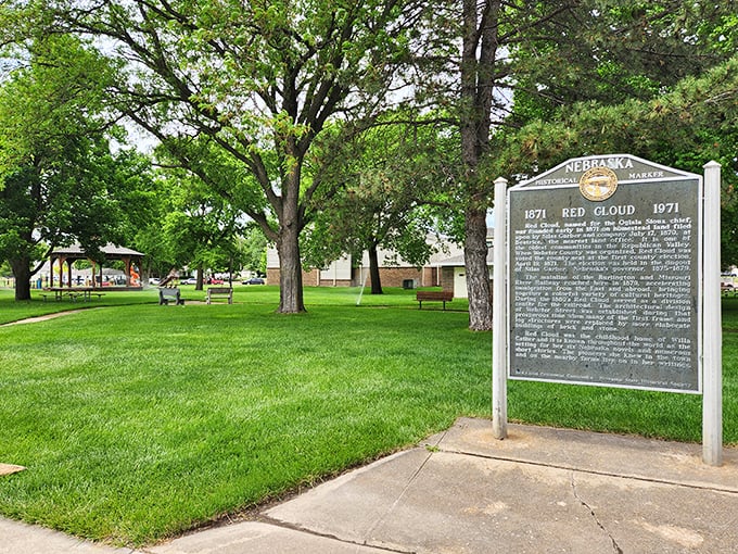 The town's historical marker stands amid a carpet of green, offering a moment of reflection on Red Cloud's journey from frontier settlement to literary landmark.