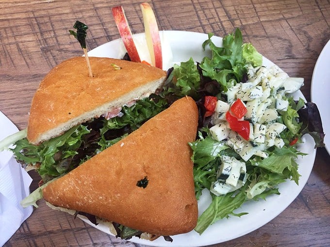 This isn't just a sandwich&mdash;it's architecture with flavor. The perfect triangle cut reveals layers of goodness alongside a salad that didn't just phone it in.