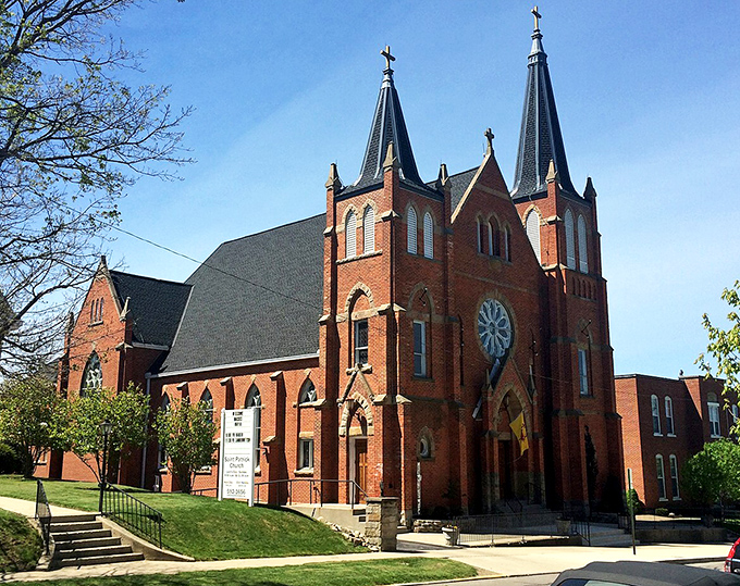 Red brick spires reach skyward, reminding you that communities once built churches like they were meant to last centuries.