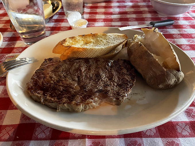 The star of the show in all its glory. A perfectly seared steak alongside a baked potato&mdash;proof that simplicity executed perfectly is culinary genius.