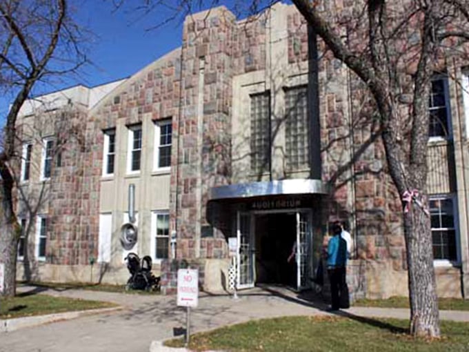 This stone auditorium stands as a testament to craftsmanship from an era when buildings were made to last generations, not fiscal quarters.