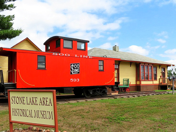 All aboard nostalgia! The vibrant red Soo Line caboose at Stone Lake Historical Museum proves some things are worth preserving besides your grandmother's cookie recipe.