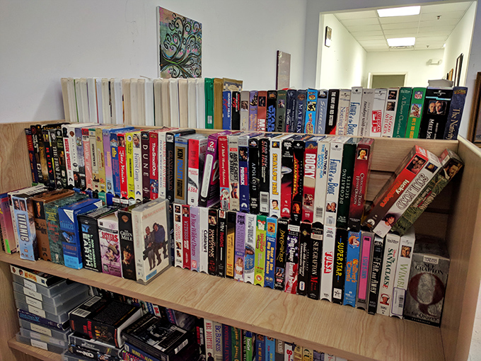 VHS tapes stand like time capsules on wooden shelves—physical artifacts from the era when "be kind, rewind" was our collective mantra.