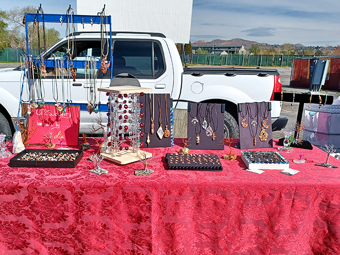 Jewelry dreams come true on this crimson-draped table, where necklaces dangle like possibilities waiting to be claimed.