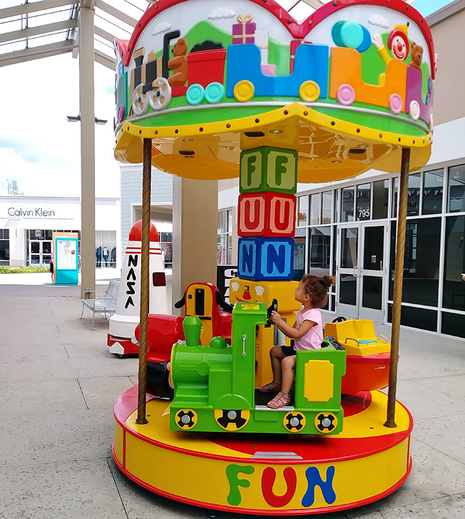 Childhood joy meets parental shopping breaks. This colorful carousel offers the perfect distraction while wallets recover between stores.