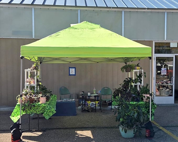 The plant vendor's setup looks like Mother Nature opened her own pop-up shop, complete with theatrical green tent.