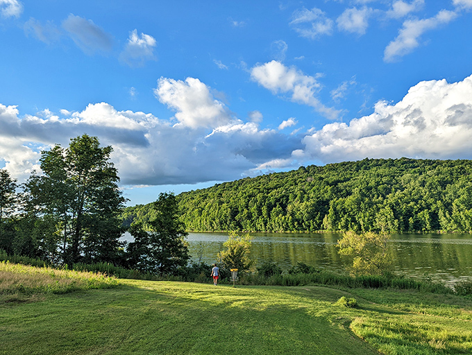 Two figures enjoying nature's theater&mdash;a sweeping vista of green hills and reflective waters that beats any 4K screen money can buy.
