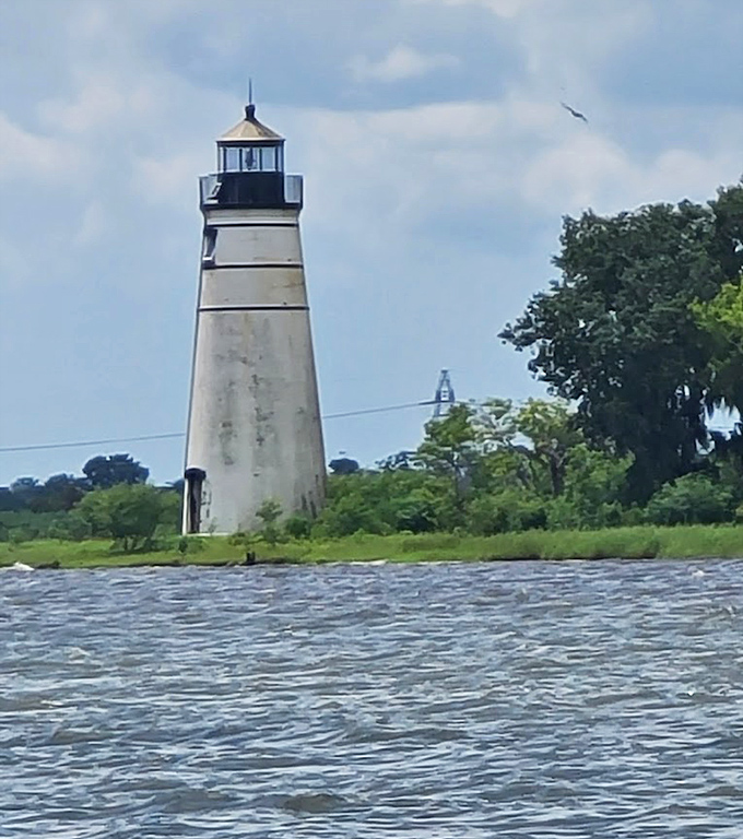 The rippling waters of Lake Pontchartrain create a shimmering pathway to this historic sentinel, standing guard where river meets lake.