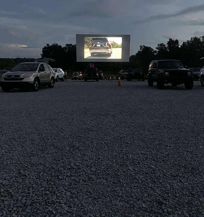Movie night in progress! The glow of the screen casts a spell over rows of vehicles, each a private theater with the best seats in the house.