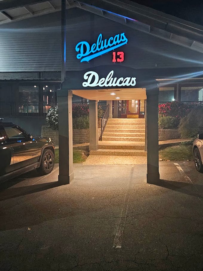 Deluca's blue neon sign cuts through the darkness, a midnight lighthouse guiding hungry souls to pizza perfection.