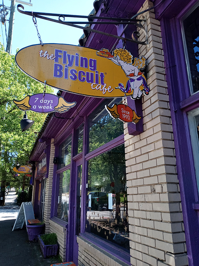 The Flying Biscuit's whimsical sign hints at the playful breakfast experience waiting inside this purple palace of morning delights.