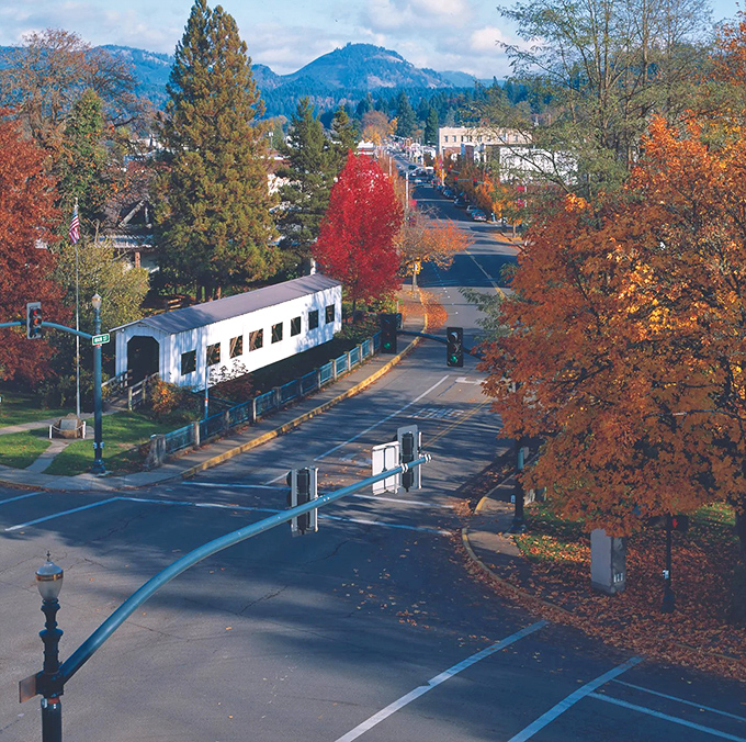 Colorful autumn trees brighten the charming streets of Cottage Grove as the historic covered bridge adds a peaceful touch to this scenic town.