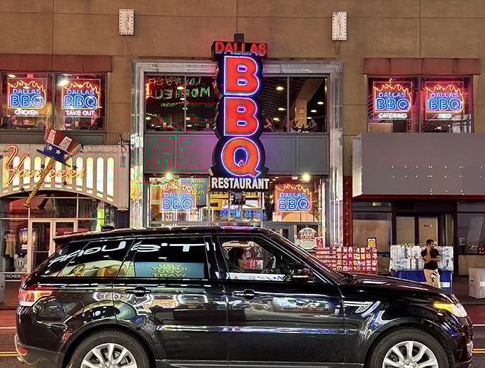 When BBQ meets Broadway! Dallas BBQ's electric signage lights up the night like a meat-lover's marquee, promising star performances of sizzling, sauce-slathered delights.