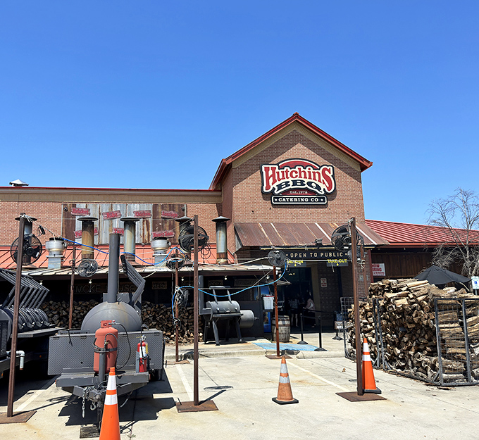 Hutchins' smokers stand like sentinels guarding flavor. The woodpile isn't decoration&mdash;it's the secret ingredient to barbecue bliss.